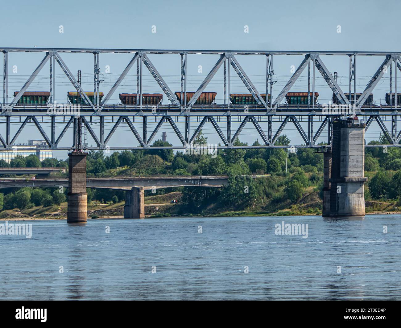 Railway metal bridge over the river. A freight train with wagons for ...