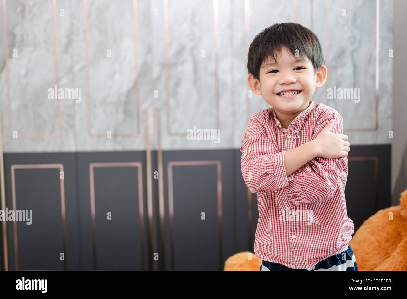Asian boy standing with arms crossed smile happily Stock Photo - Alamy