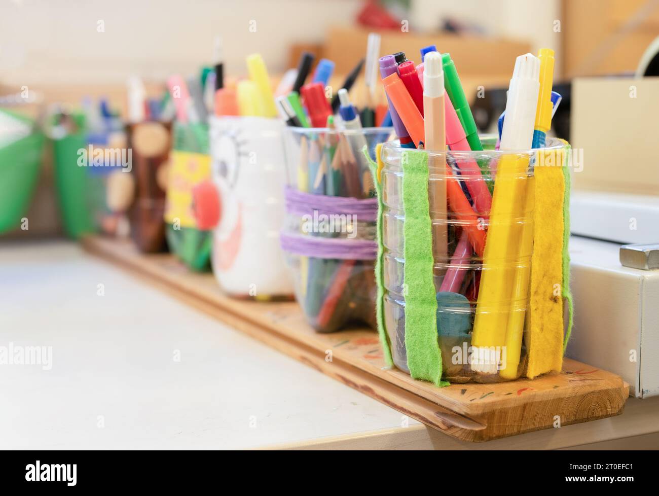 Many coloring pens and pencils in pencil holders on worktable in art ...