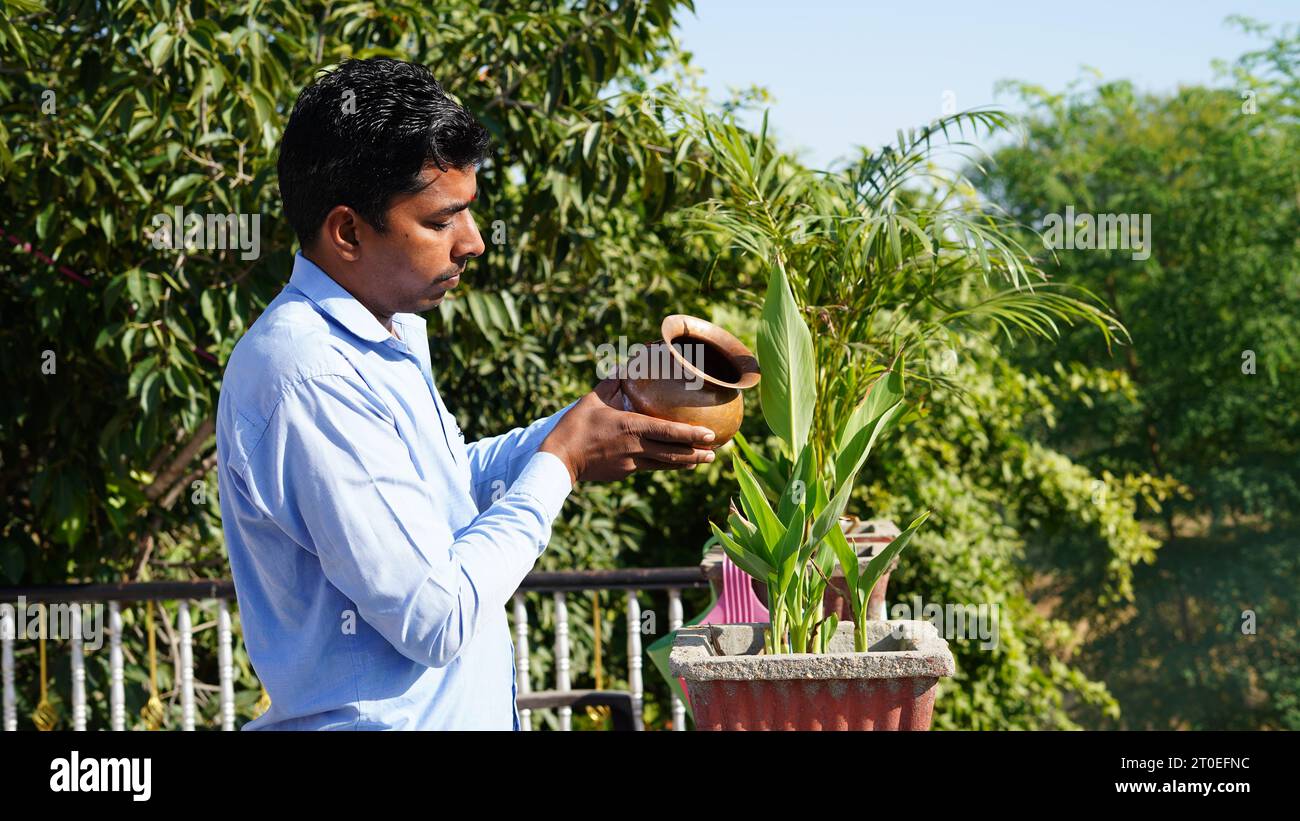 Hindu devotee offering water or Ardhya to the sun God at home on ...