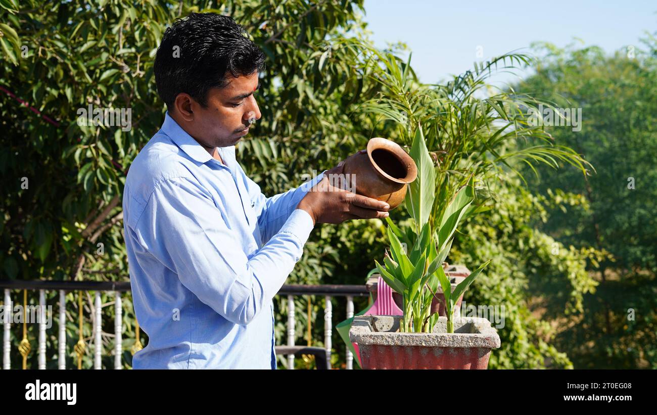 Hindu devotee offering water or Ardhya to the sun God at home on ...