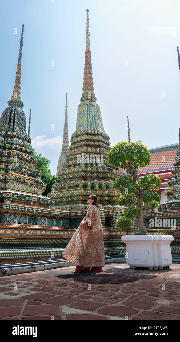 A young female stands confidently in front of a towering cityscape ...