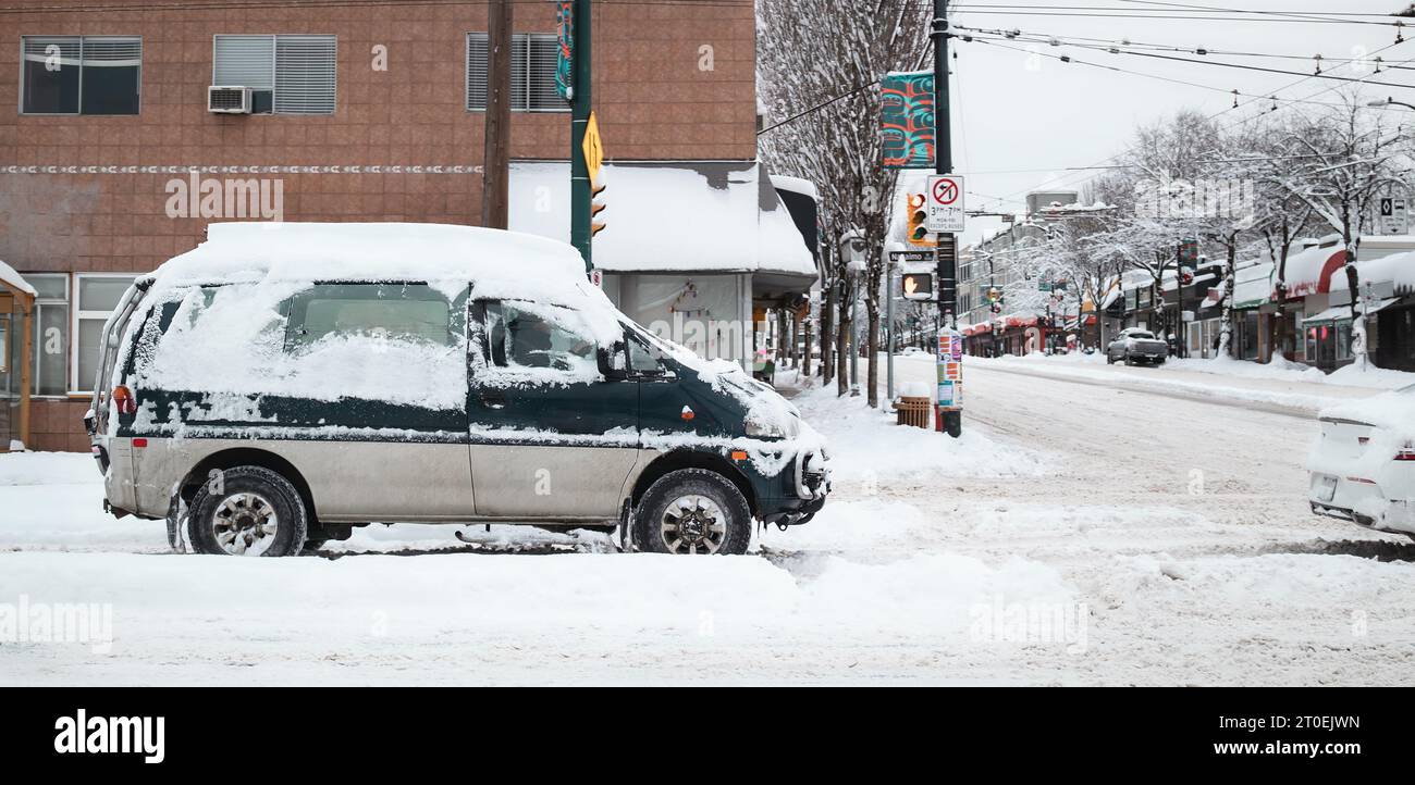 Car driving with snow on roof on slush and icy main street. Vehicles ...