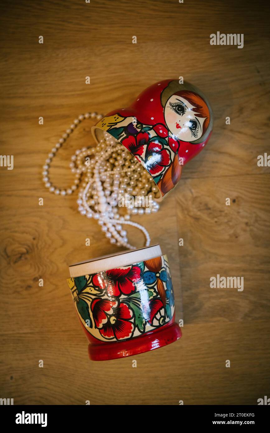 Beaded necklaces and open matryoshka on wooden floor Stock Photo - Alamy