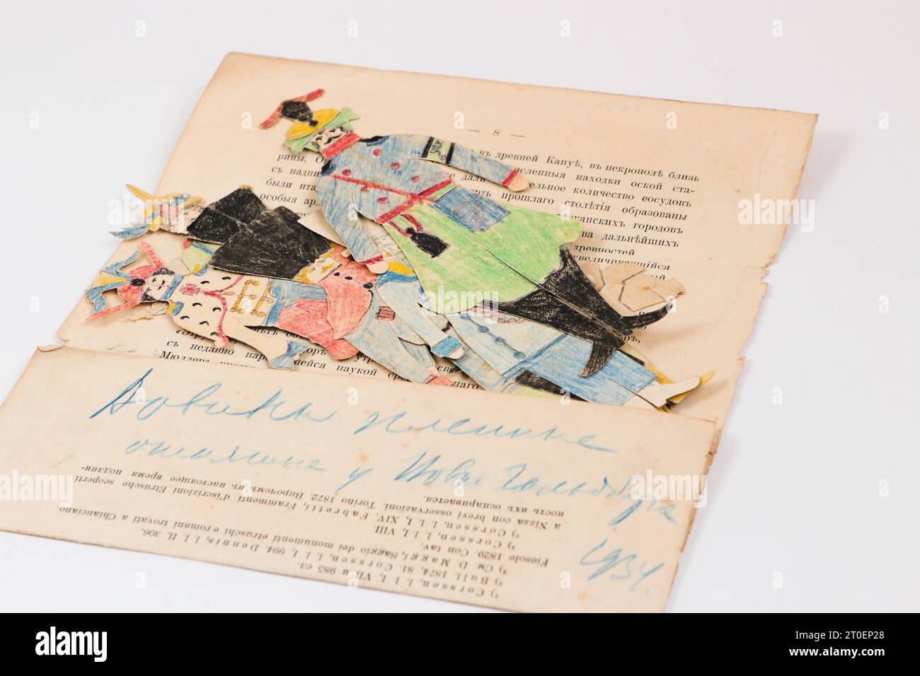 Handmade figures for childish play cut out from paper put in book page ...
