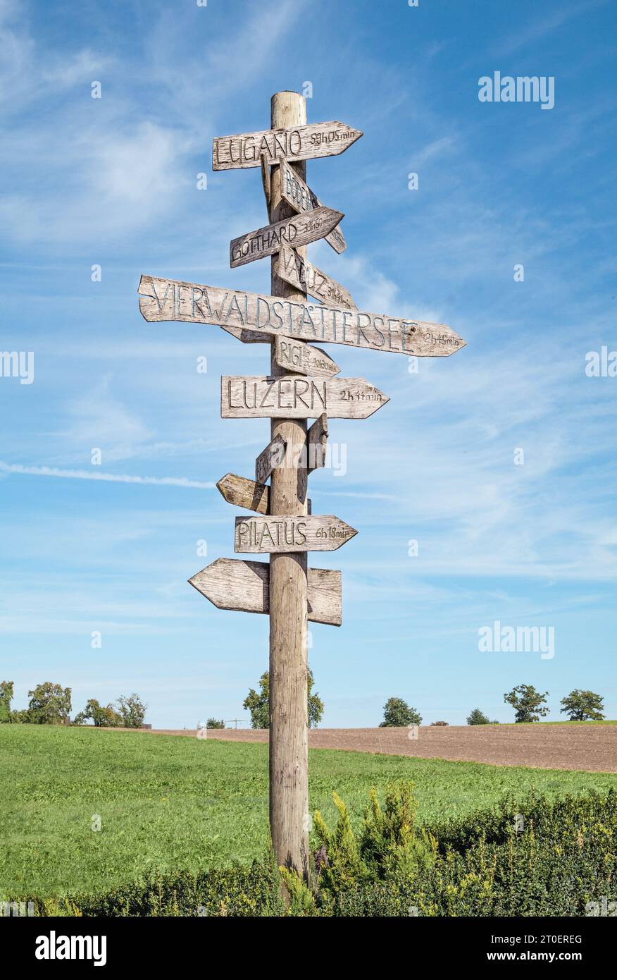 Wood signpost with cities and places in Switzerland and the distance ...