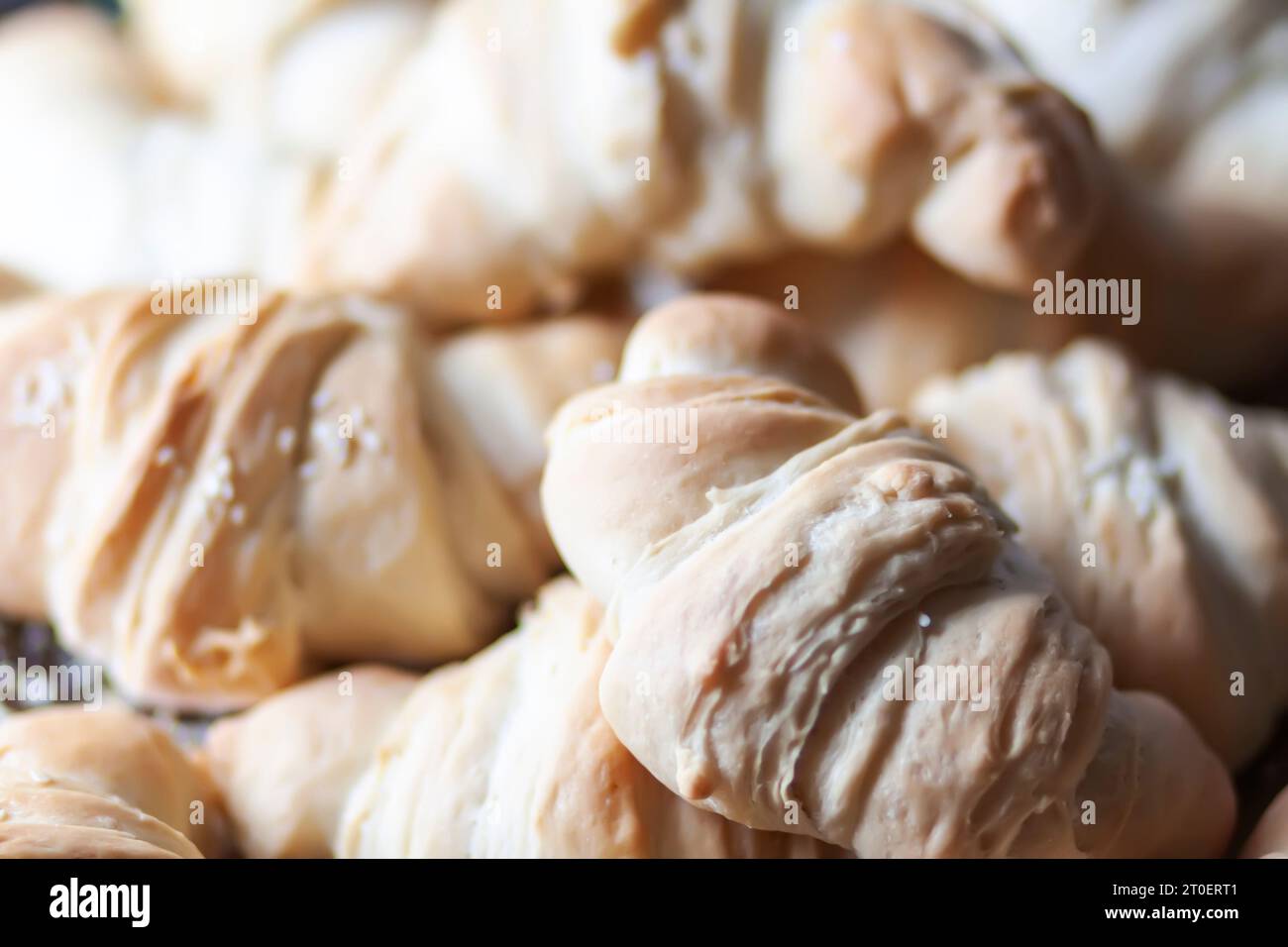 Raw croissant rolls in baking process Stock Photo - Alamy