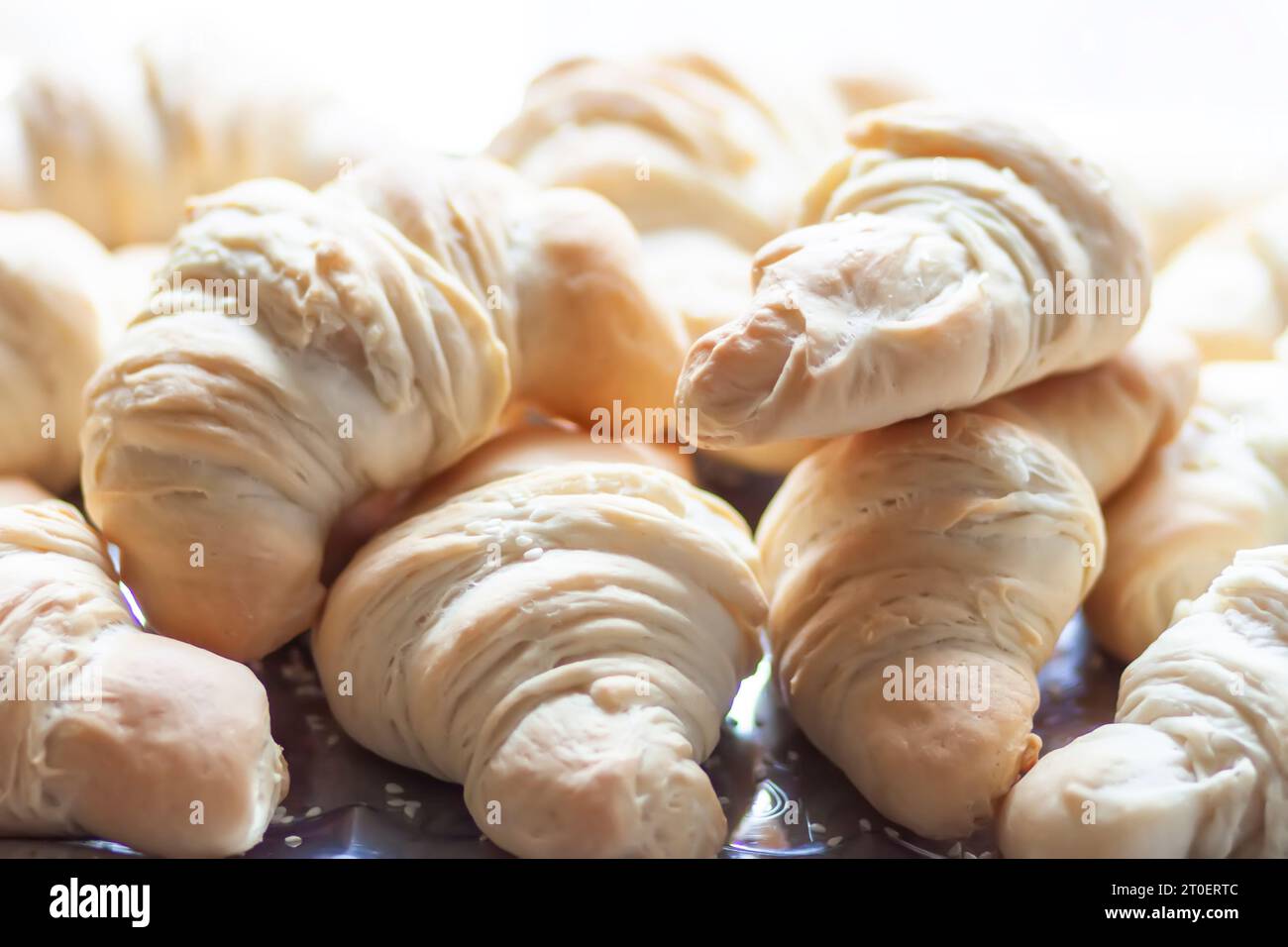 Raw croissant rolls in baking process Stock Photo - Alamy