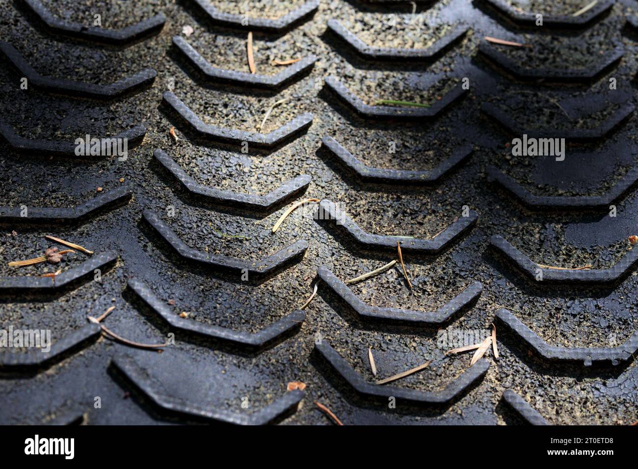 Abstract black rubber mat texture in forest, close up. Defocused tire ...