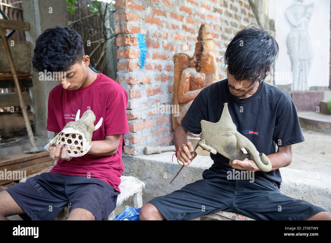 Young men making traditional mythical animal masks from clay, Majuli ...