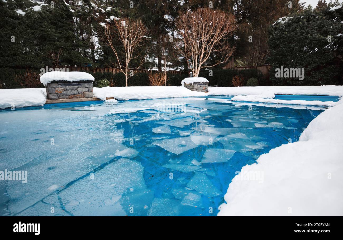 Pool with ice and slush after snow storm. Inground pool with pool cover ...