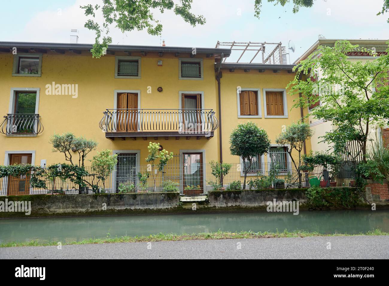Beautiful apartment building by the river in the Alps of Italy. Travel ...