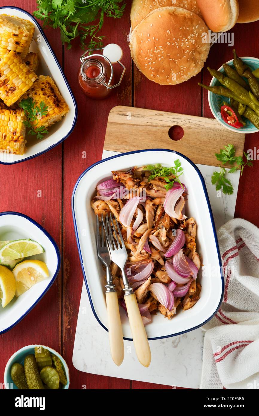 Pulled bbq chicken with baked onions on serving platter, bbq corn ...