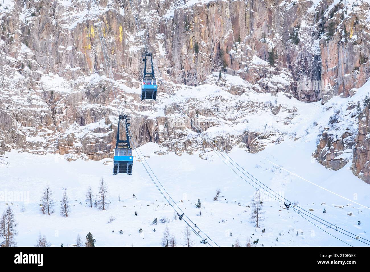 Low angle view of cable car cabins transporting skiers and tourists up ...