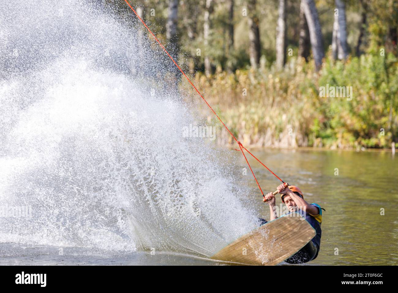 Sportsman on wakeboard falling after a trick on his back raising lots ...