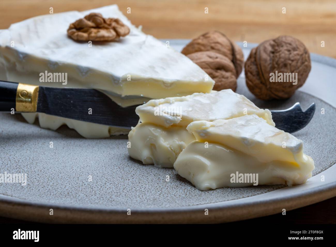 Piece of french soft-ripened white mold cow milk cheese brie produced ...