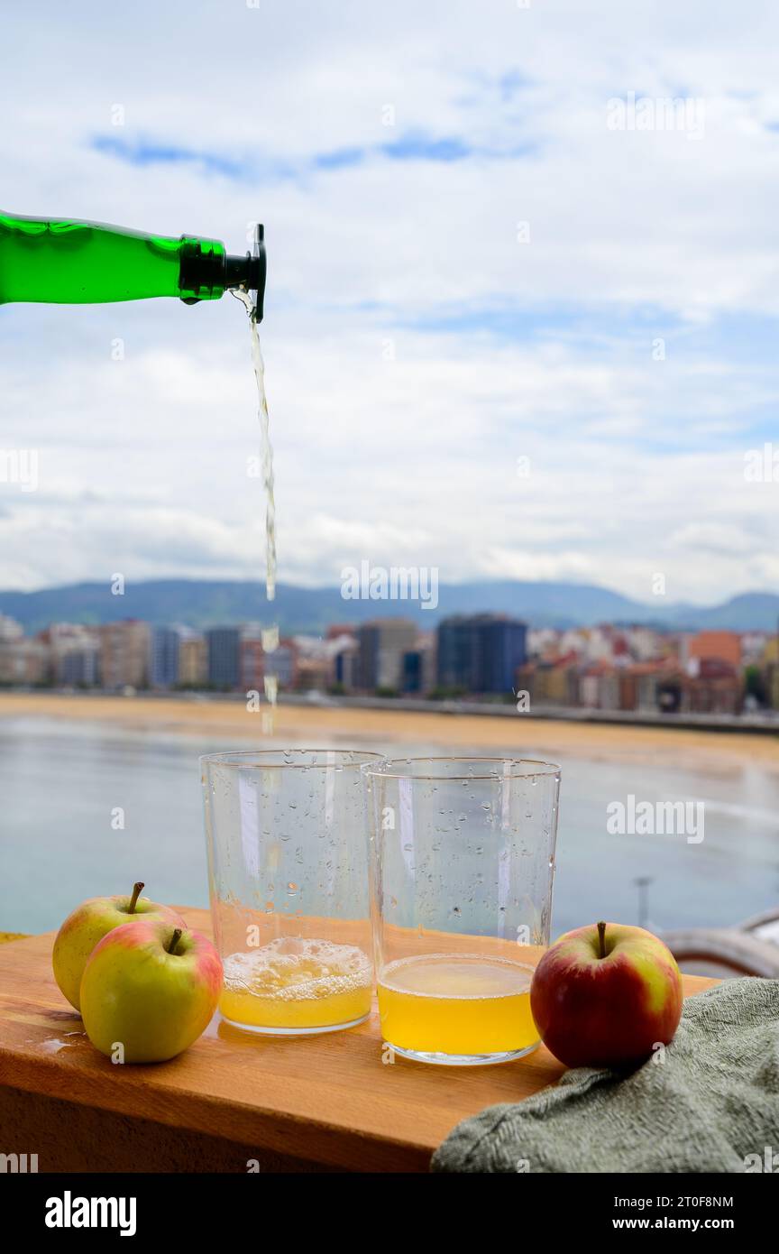 Pouring of natural Asturian cider made from fermented apples in wooden ...