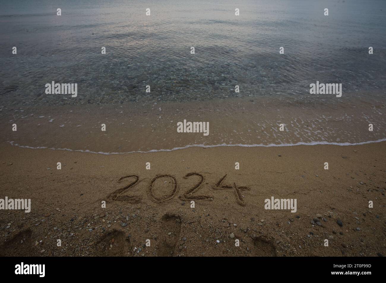 New Year 2024, lettering on the beach with wave and clear blue sea ...