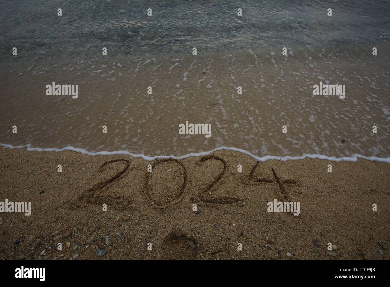 New Year 2024, lettering on the beach with wave and clear blue sea ...