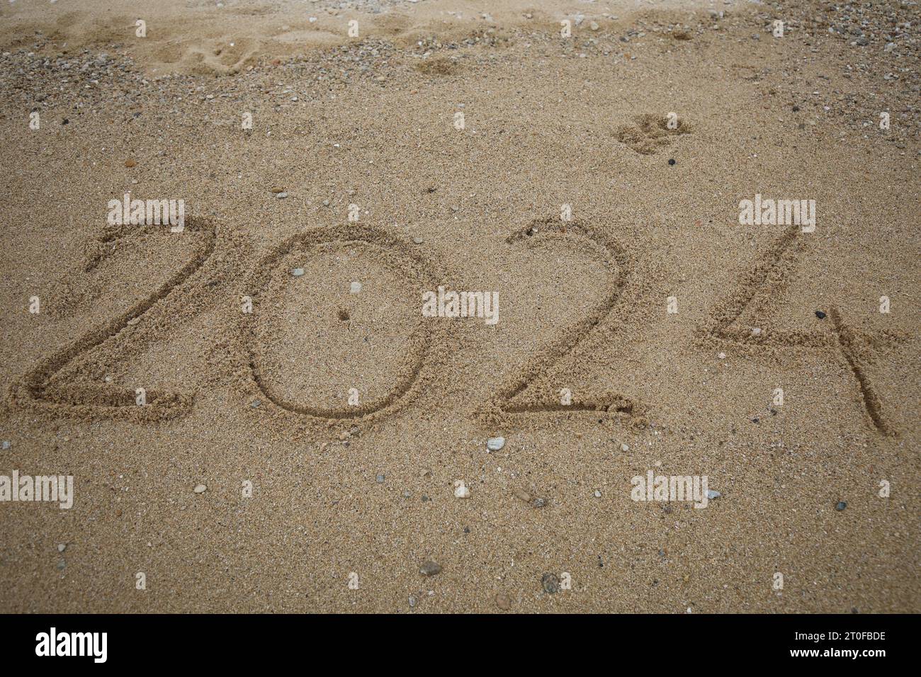 New Year 2024, lettering on the beach with wave and clear blue sea ...