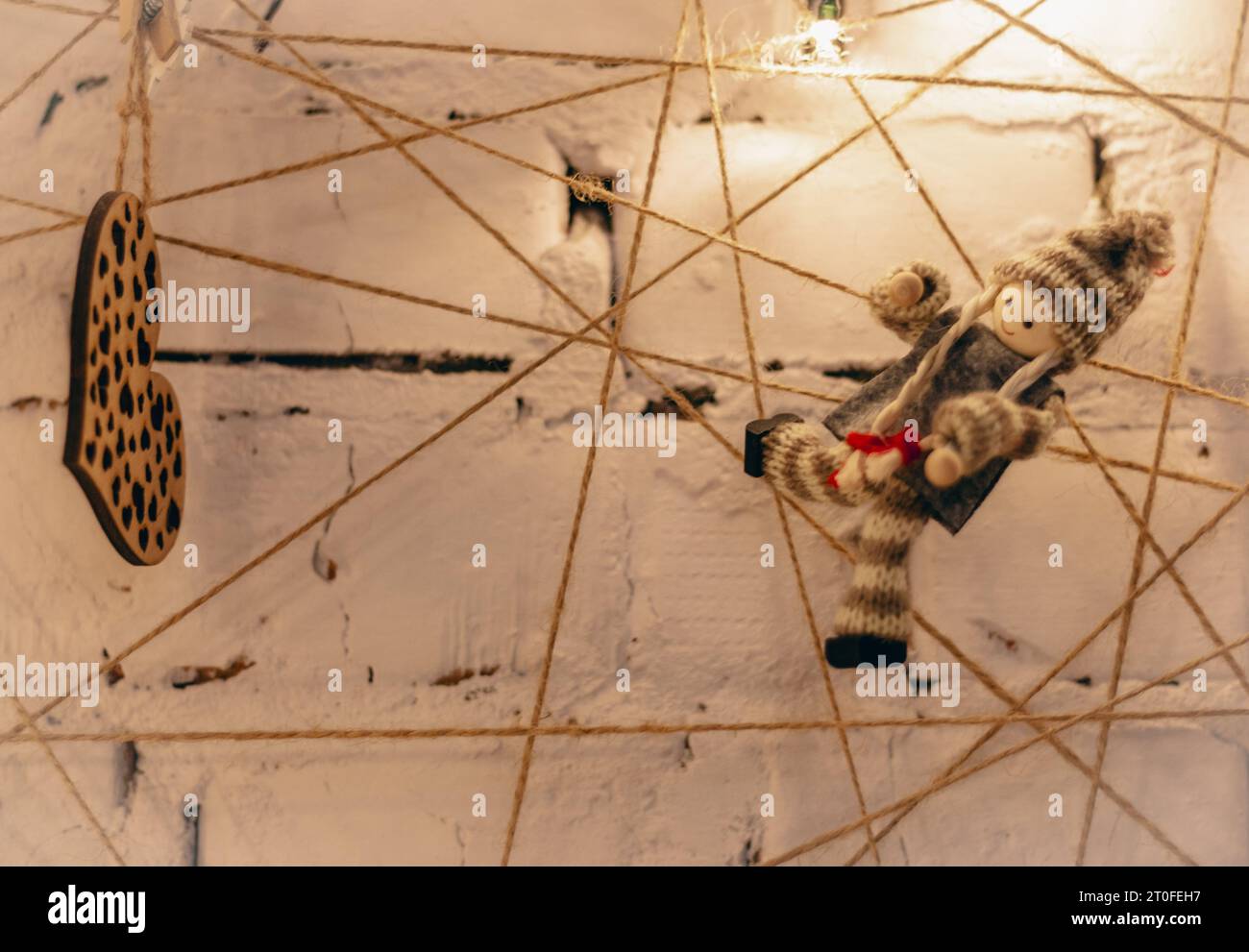 Small doll with pin on the rope. Festive string art concept. Garland ...