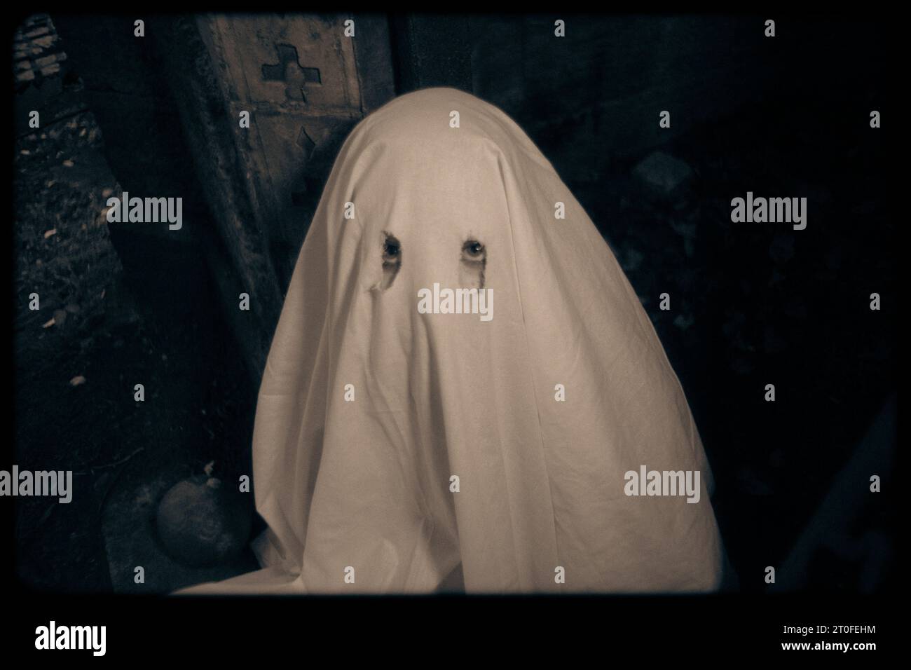 A woman in a frightening white ghostly garment with eye-hole cutouts ...