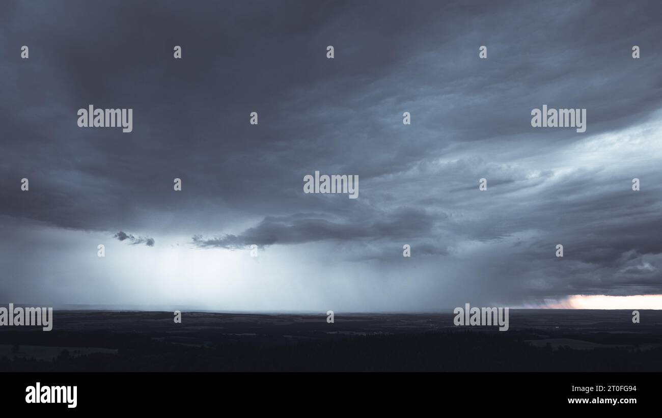 Big dark storm with sunbeams coming through them in the background. On ...