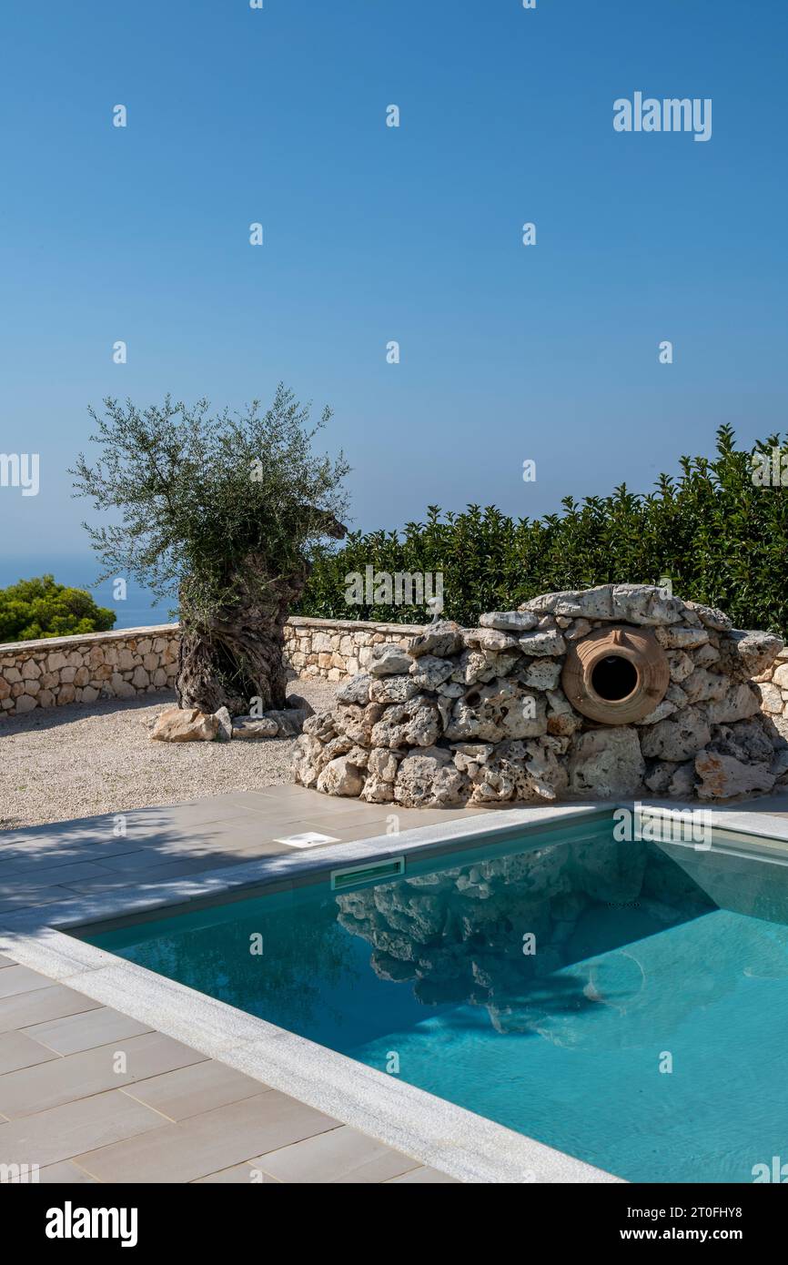 swimming pool and greek urn under a blue clear sky on the greek island ...