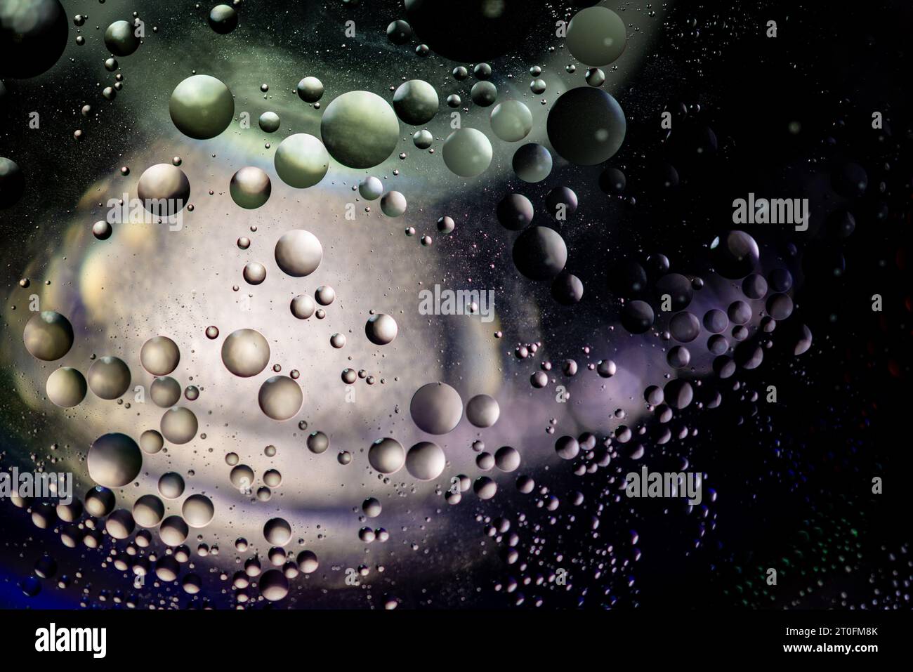 Mix of oil and water forming patches of oil rings and discs over a ...