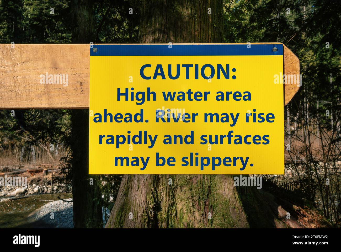 Trail caution sign about high water and fast rising river. Yellow large ...