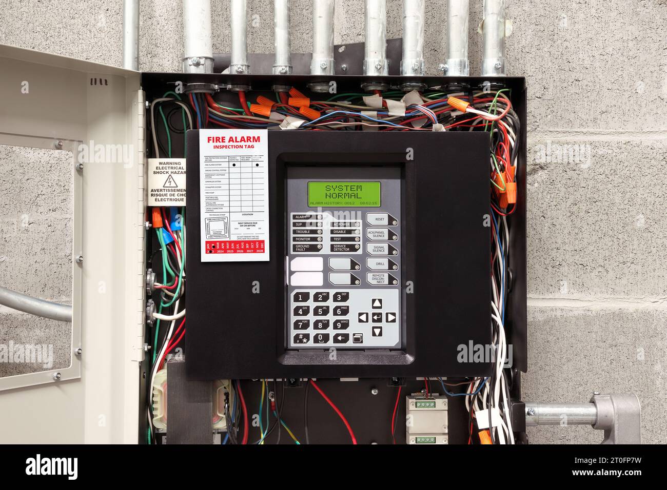 Fire alarm control panel in service room with fire inspection tag. Open ...