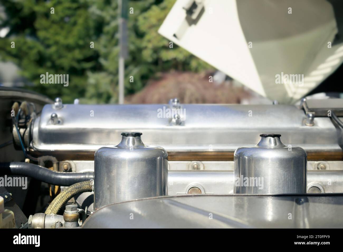 Vintage sports car engine components on a sunny day. Open car hood ...