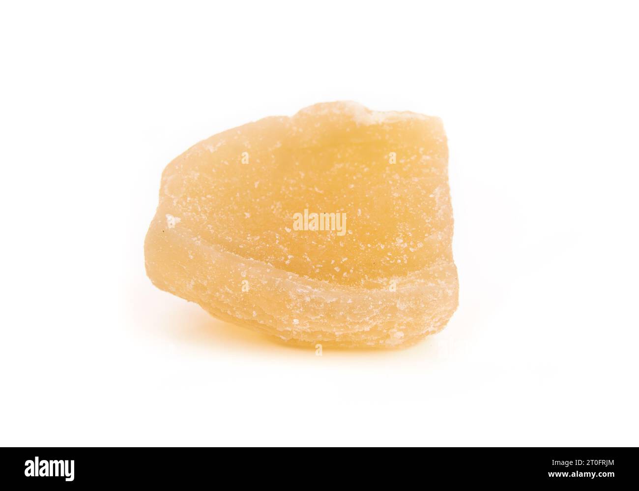 Isolated candied ginger piece, close up. Yellow chunk of candied or ...