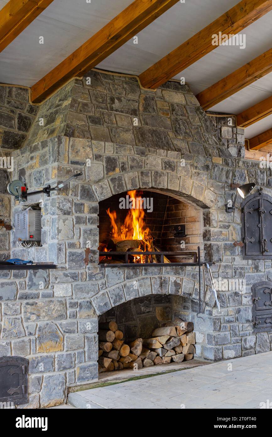 Burning stone barbecue firewood with fire, open brick oven for cooking ...