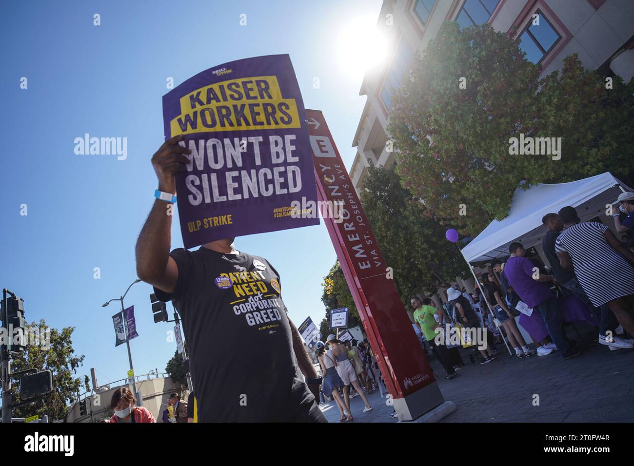 A Kaiser Permanente worker holds a placard during the demonstration. On ...
