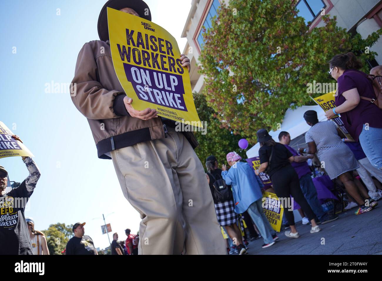 A Kaiser Permanente worker holds a placard during the demonstration. On ...