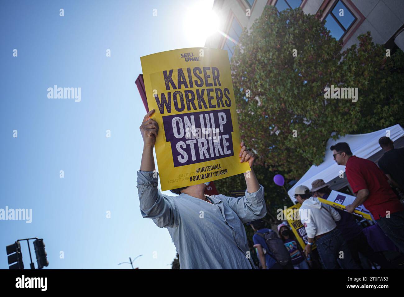 A Kaiser Permanente worker holds a placard during the demonstration. On ...