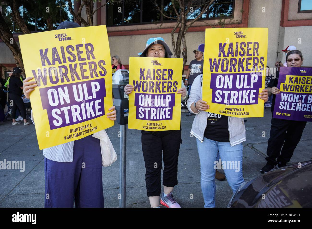 Kaiser Permanente workers hold placards expressing their opinion during ...