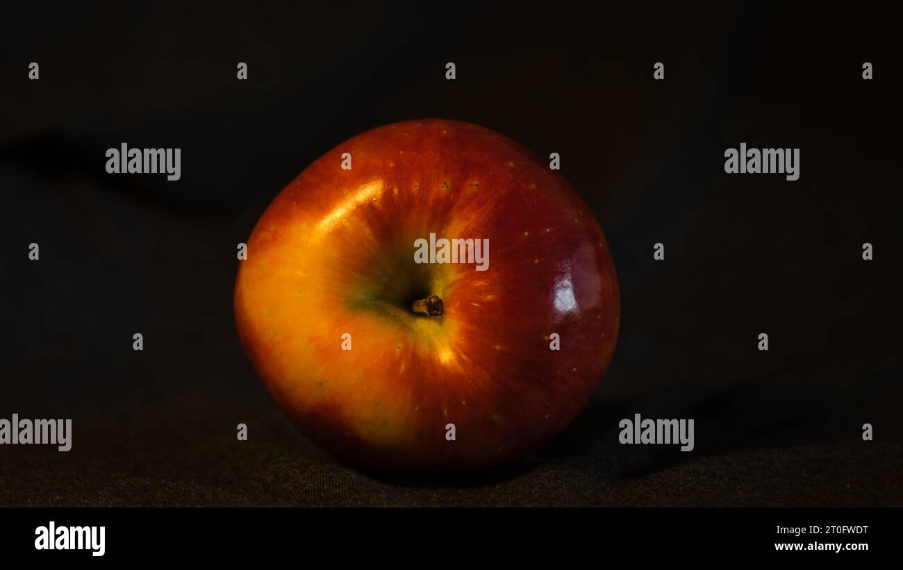 A crisp apple, a symbol of good health and wellness, set against a grey ...