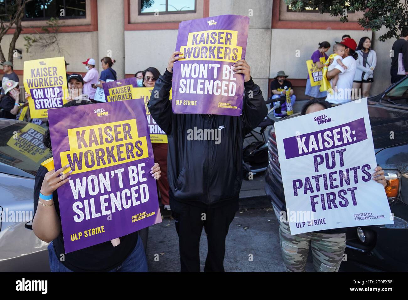 Kaiser Permanente workers hold placards expressing their opinion during ...