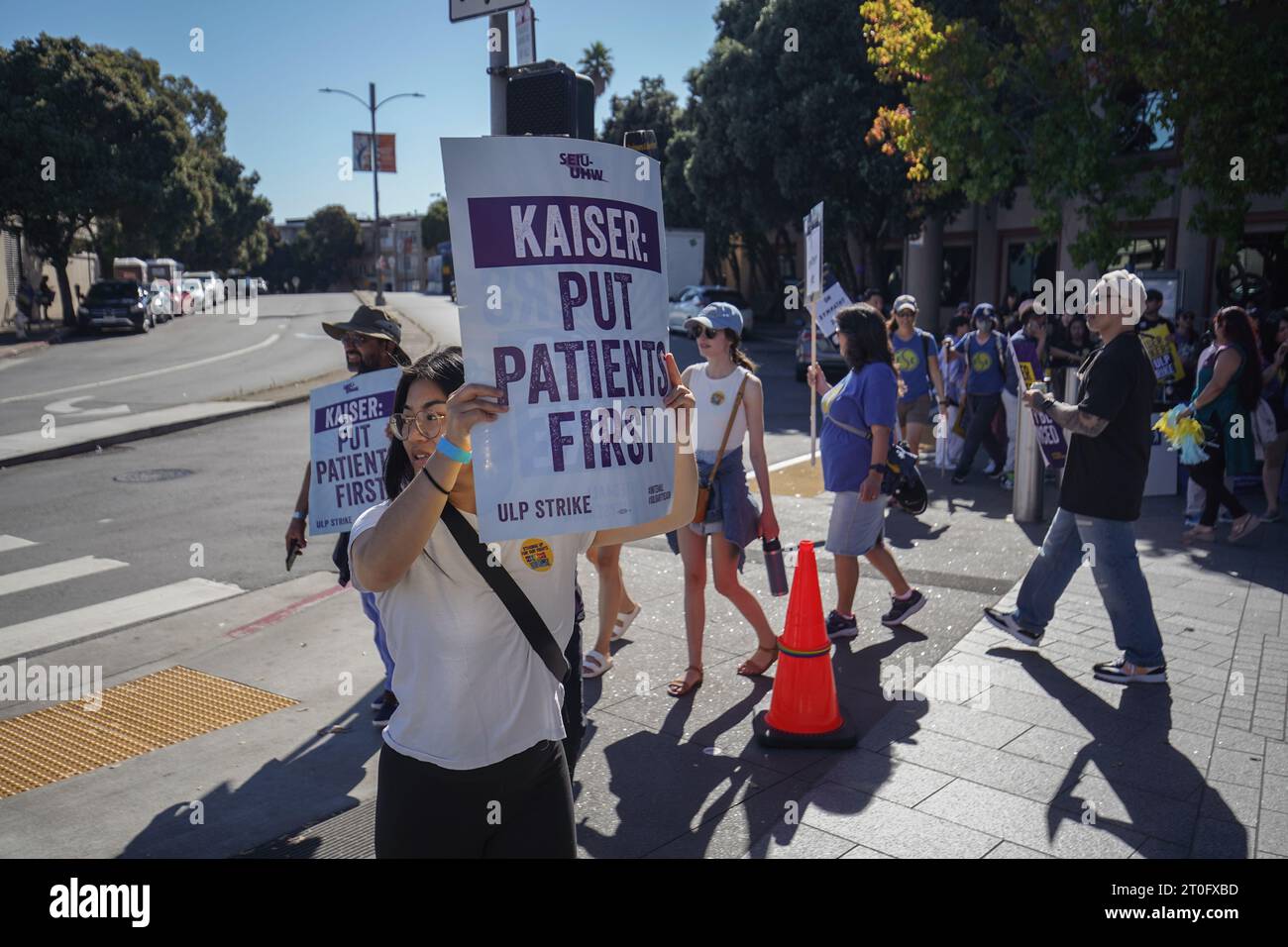 A Kaiser Permanente worker holds a placard during the demonstration. On ...