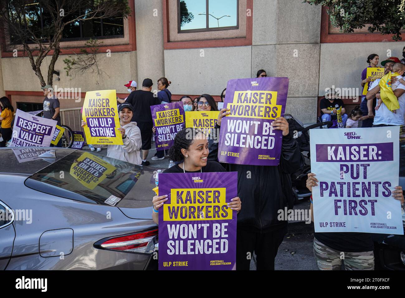 Kaiser Permanente workers hold placards expressing their opinion during ...