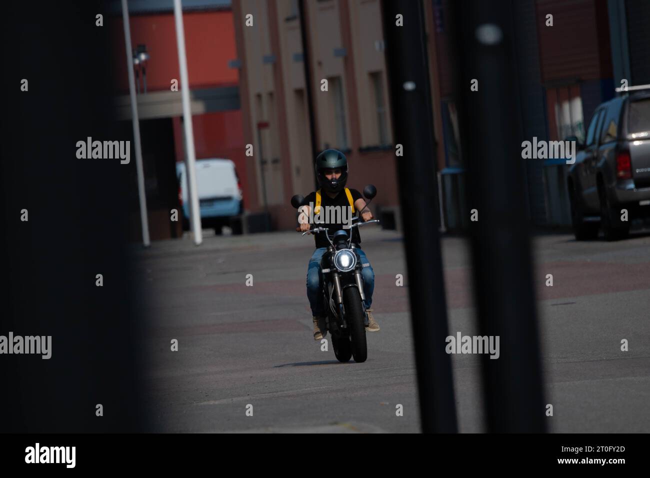 A helmeted rider on a slick motorcycle speeds through a bustling city ...