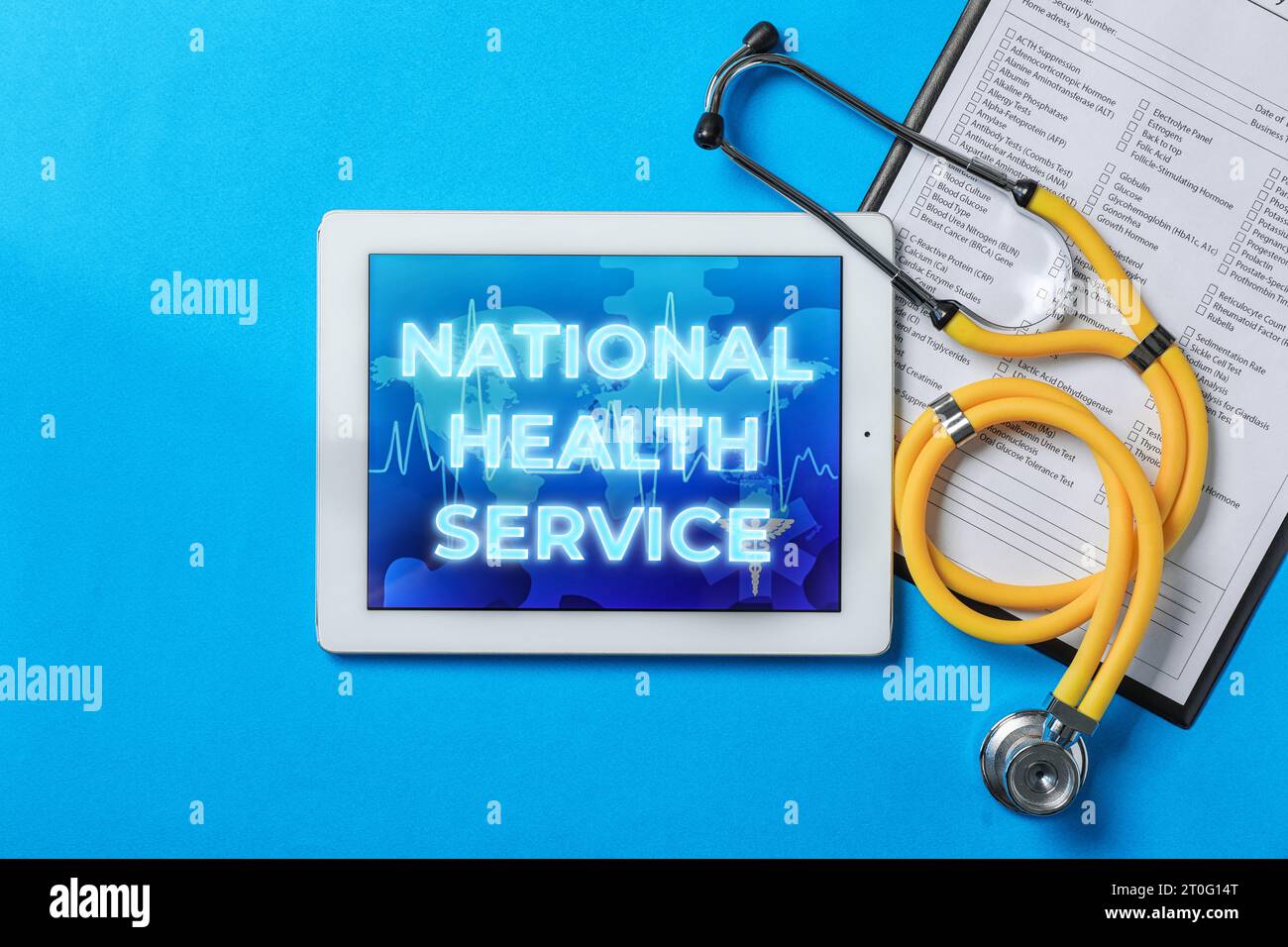 National health service (NHS). Tablet with text, stethoscope and test ...