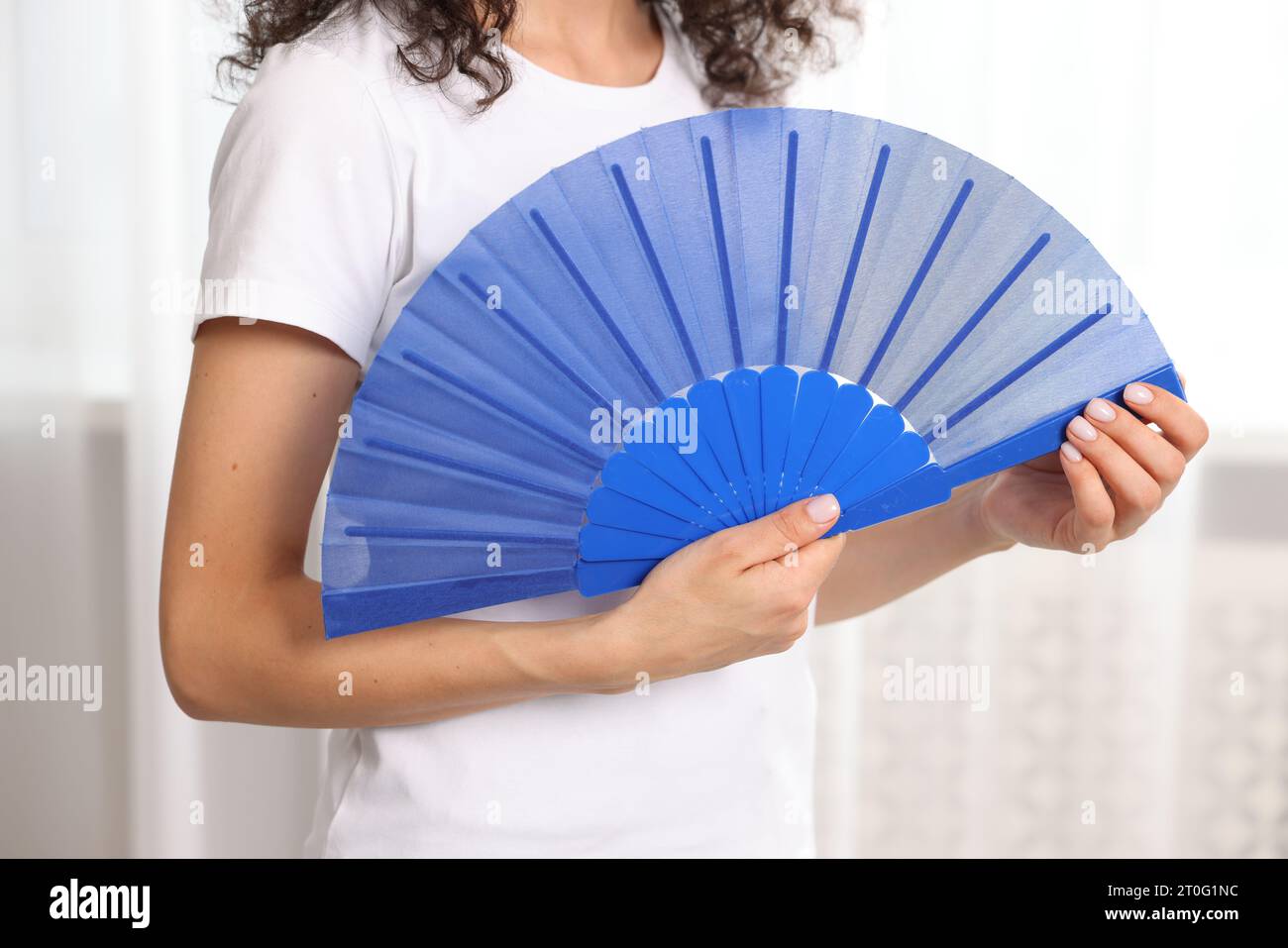 Woman using handheld fan hi-res stock photography and images - Alamy