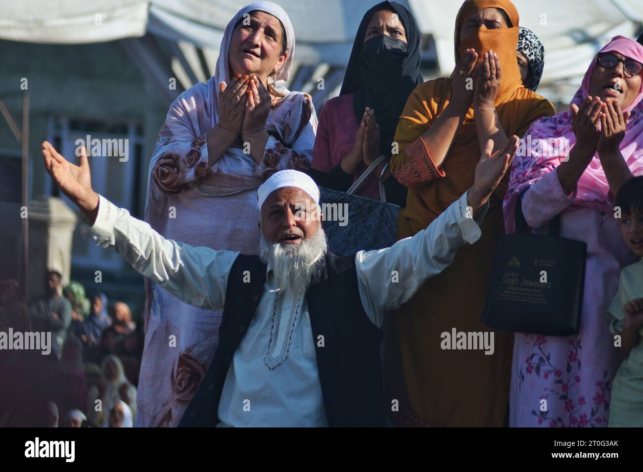 Muslims pray as the imam (not in picture) displays the holy relic of ...