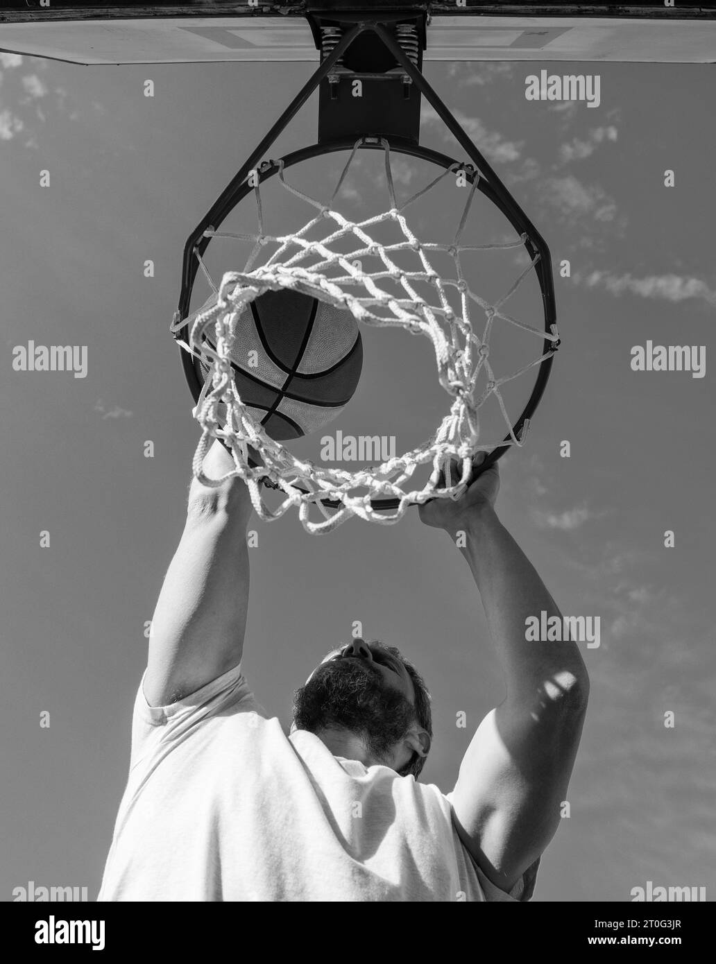 basketball player throws the ball into the hoop outdoors, male ...