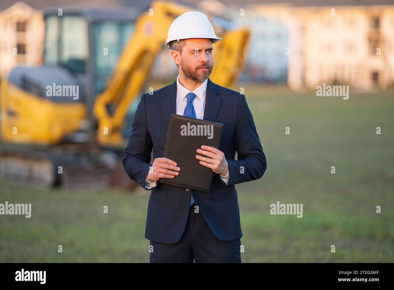 Architect at a construction site. Architect man in helmet and suit at ...