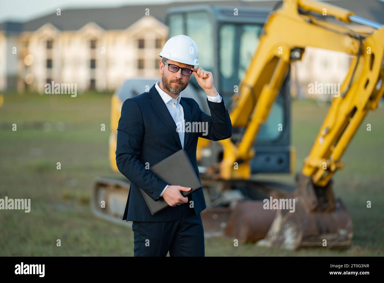 Construction manager in suit and helmet at a construction site ...