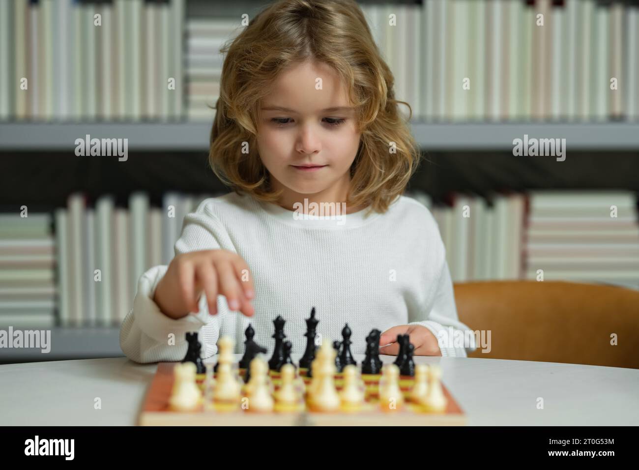 Chess school. Concentrated child play chess. Kid playing board game in ...